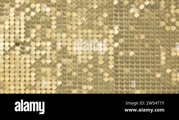 rows of blinking golden yellow brass metal plaques sway in wind and ...