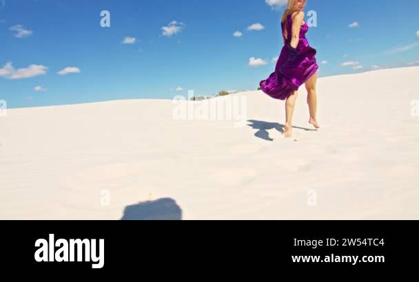 Cinematic slow motion of a woman walking on a sand dune. Barefoot woman ...