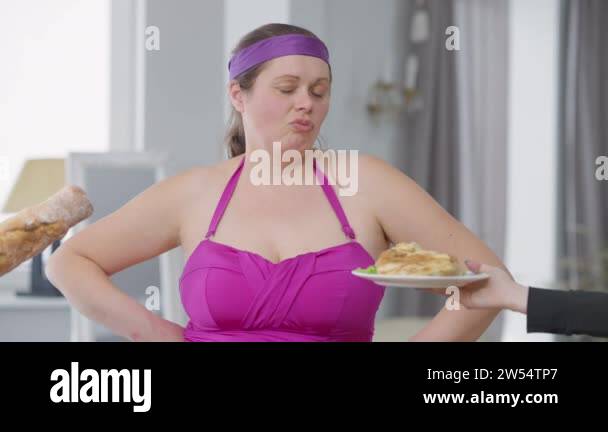 Portrait of young overweight woman refusing unhealthy junk food shaking ...