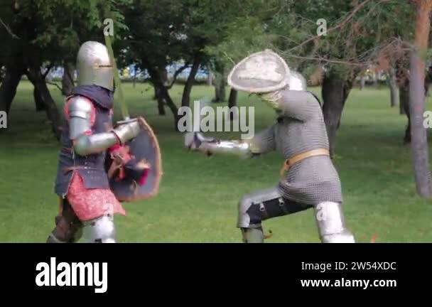 Battle of two medieval warriors in full sets of armor with swords and ...