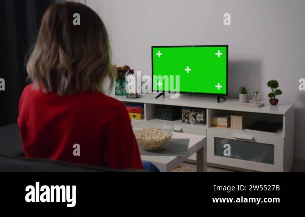 Woman watching TV focused eating popcorn. Green Screen TV Chroma Key ...