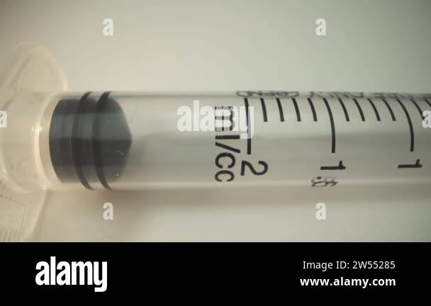 A new disposable syringe lies on a white table. Panoramic view along ...