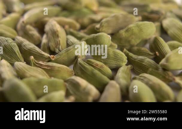 Dried cardamom seeds fall in a heap in slow motion. Macro. Rotation ...