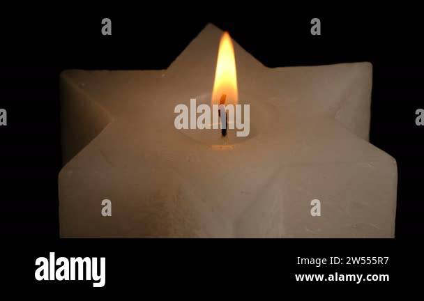 A commemorative candle in the shape of a six-pointed star of David is ...