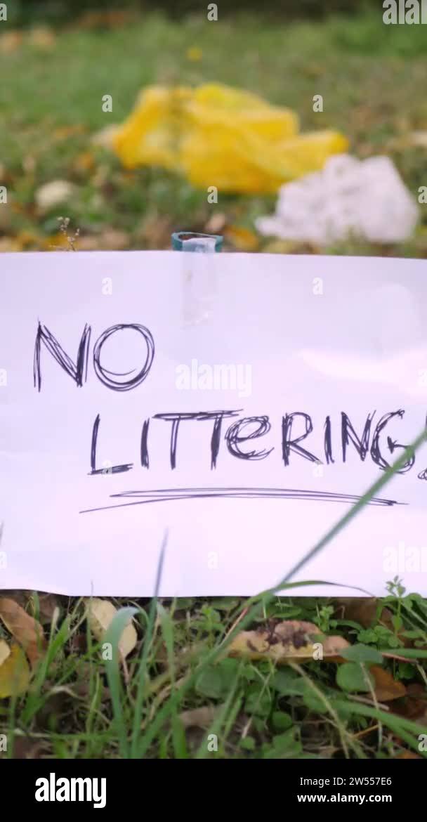 No littering sign in the park surrounded by plastic trash and ...