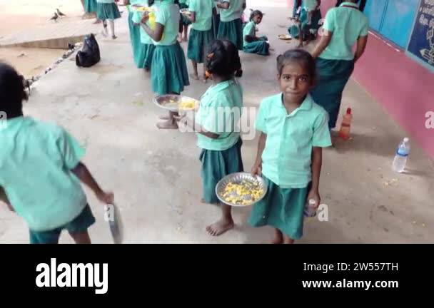 Unidentified poor classmates with uniforms sitting on the floor ...
