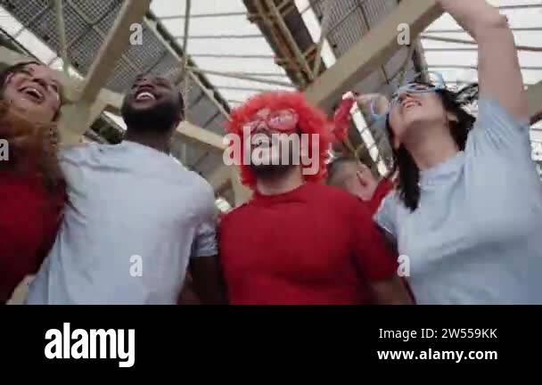 Group of people celebrating together jumping and hugging while cheering ...