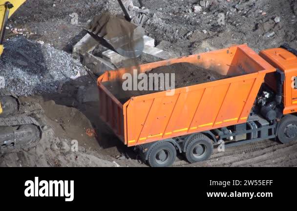 Crawler excavator working and load into dumper truck at the ...