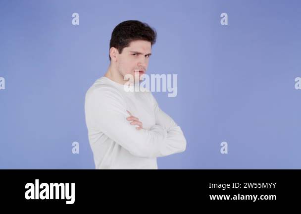 Angry offended man keeping arms crossed and staring at camera with ...