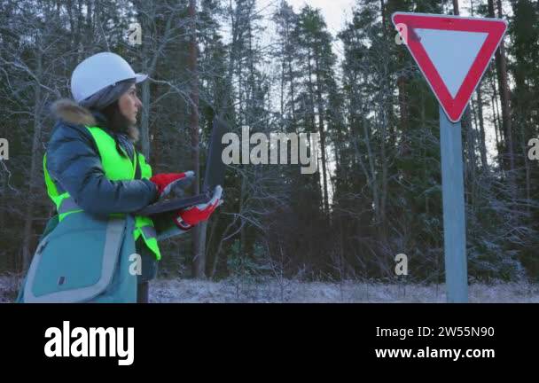 Woman engineer planning temporary movement of road signs on the forest ...