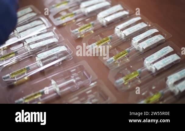 Syringes with the drug are packed by hand. Medicinal product in a ...