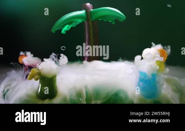 Various colorful cocktails with dry ice at beach bar with palm trees ...