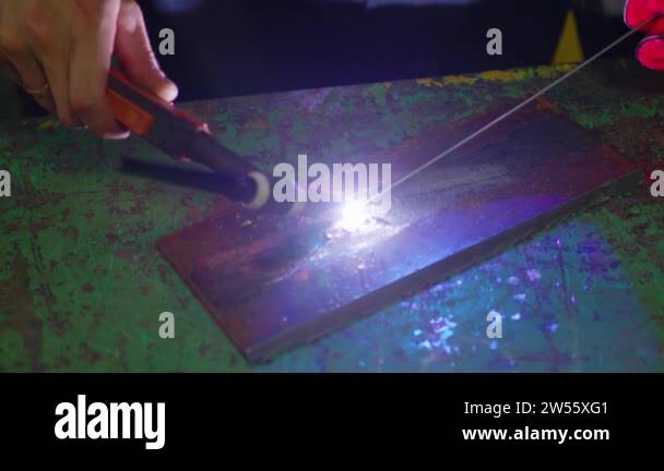 Man wearing mask welding in a workshop. Metal workers use manual labor ...