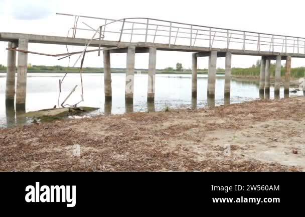 Ecological disaster. cracked soil ground and broken bridge over dried ...