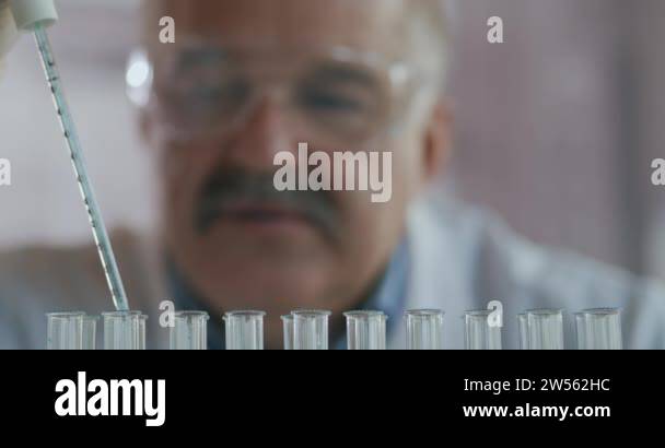 Scientist drop liquid in a test tube and shaking in laboratory. Pipette ...