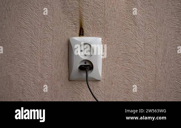 Smoke comes from a faulty outlet in the apartment. The concept of the ...