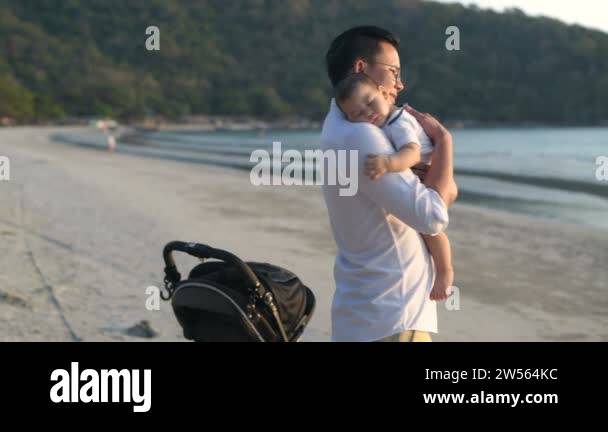 Family concept. Father raising a baby by the beach. 4k Resolution Stock ...