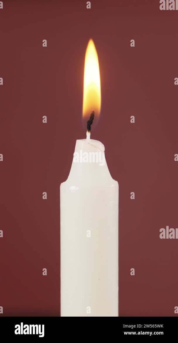 A Single Candle is Lit on a Red Background. Lighting. Candle Flame ...