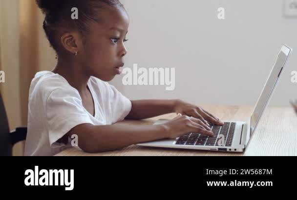 Afro american preschool girl typing keyboard of laptop computer sitting ...