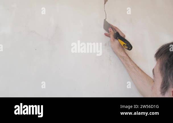 Construction man worker repairing a crack wall of a home, plastering ...