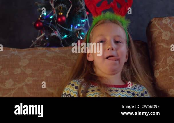 Happy little girl in red deer horns laughs and looks into camera at ...