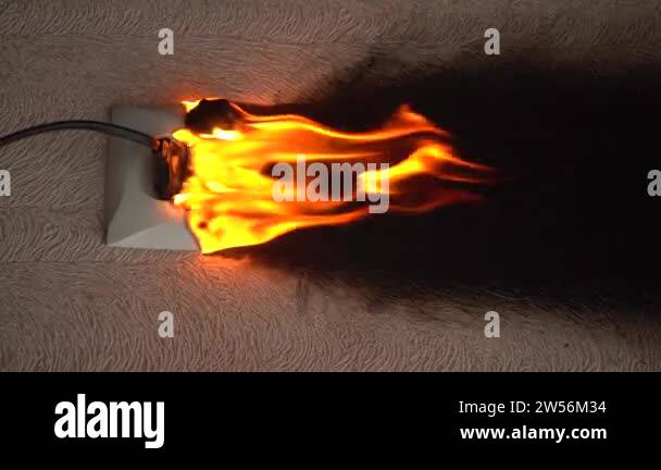 Vertical video. The electrical outlet has caught fire. The plug of the ...