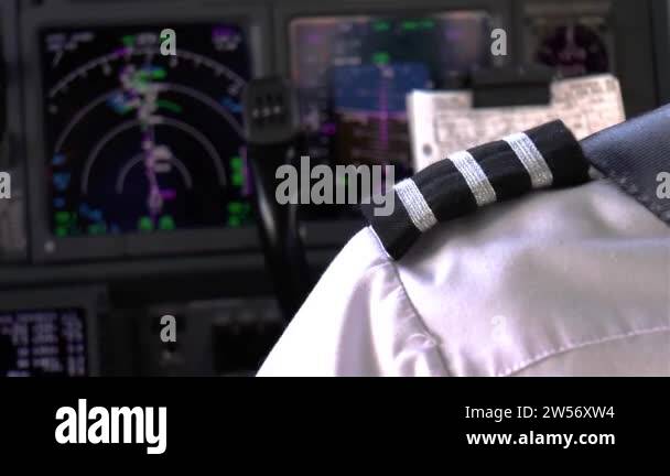 Pilot in the flight deck of a modern airliner. A pilot monitors the ...