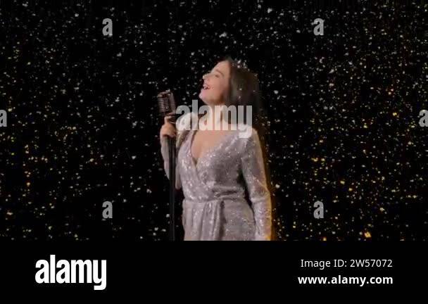 Portrait of a beautiful singer with a vintage microphone against the ...