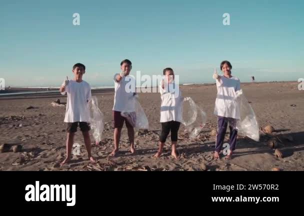 Dollying-in medium portrait of young asian people holding garbage bags ...