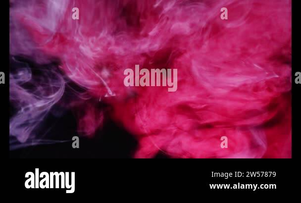 Whimsical movement of colored puffs of smoke against a dark background ...