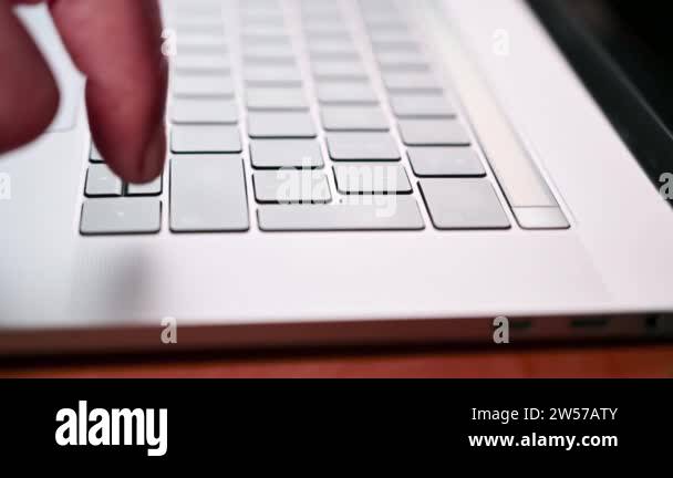 a man's hand multiple times presses the enter button on a laptop. Work ...