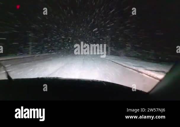 Inside view of front windshield of a driving in blizzard car. Empty ...