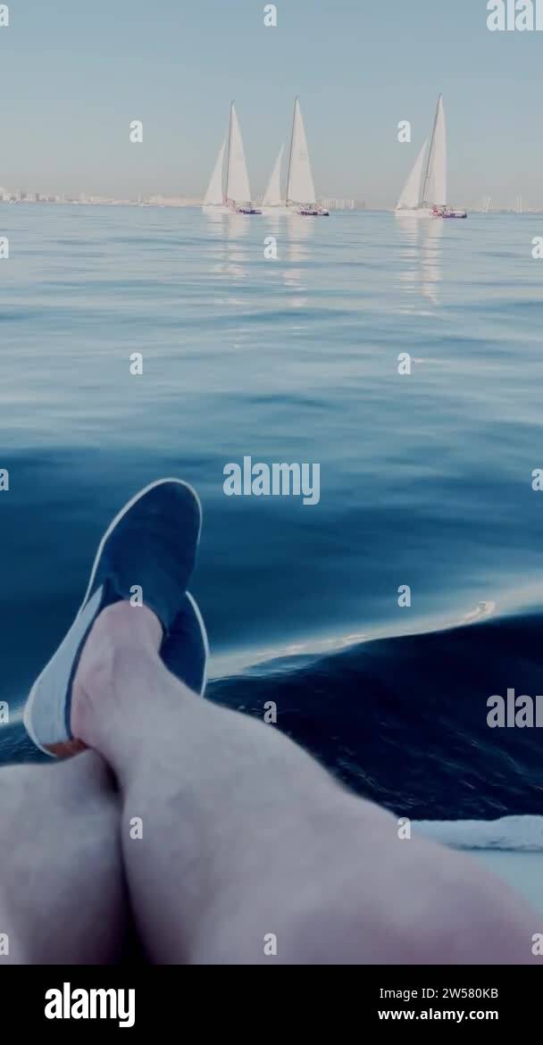 The feet of men are dressed in easy footwear lie on the edge of the ...