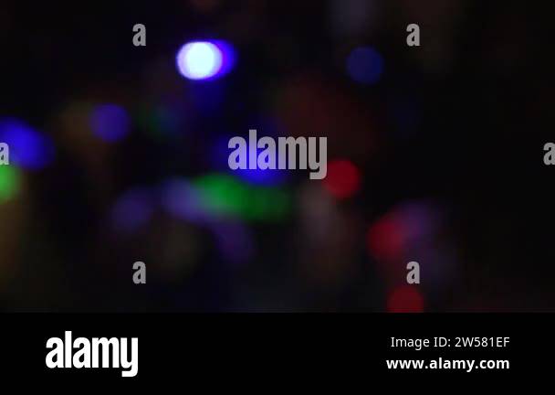 Neon lights on the dance floor. Blurry bokeh. People are jumping on the ...