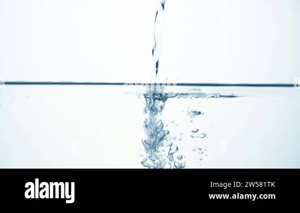 Carbonated stream of water in slow motion falls on smooth clean surface ...