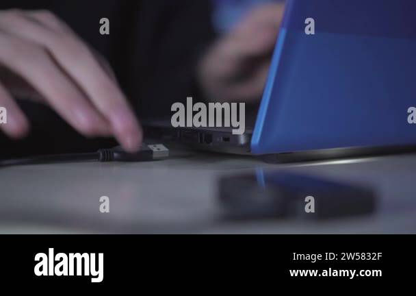 Unrecognizable man plugging in USB device into laptop. Male hand ...