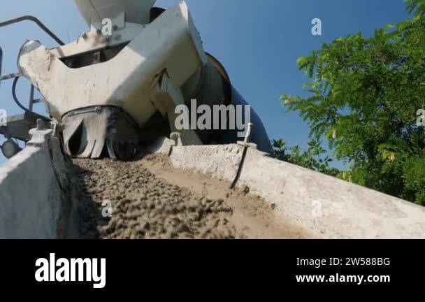 Concrete flows from the concrete mixer through the trough, concrete ...