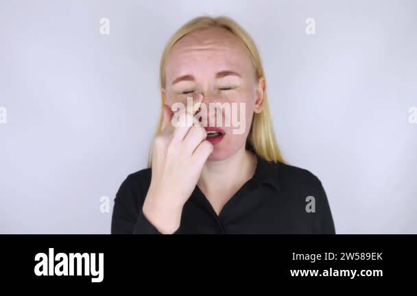 Nasal bridge pain, headache. A woman holds his nose with his hand and ...