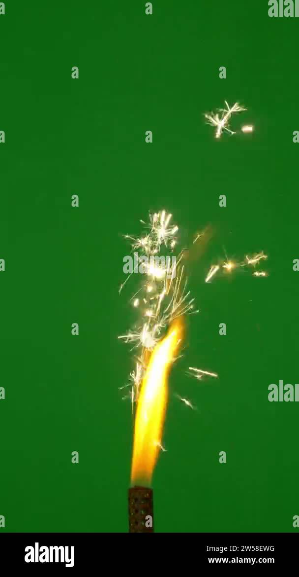 Burning bengal fire and sparks on green background in vertical in 4K ...