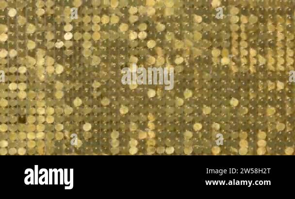 rows of blinking golden yellow brass metal plaques sway in wind and ...