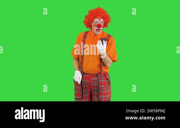 Clown with smartphone making a call on a Green Screen, Chroma Key Stock ...