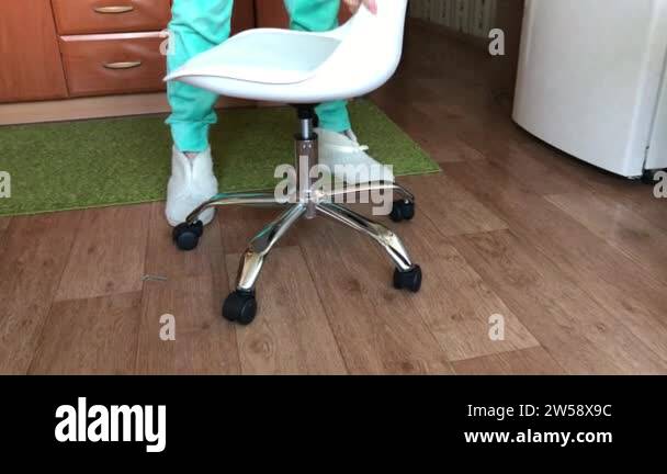 A woman places the seat on the lifting mechanism of a computer chair ...