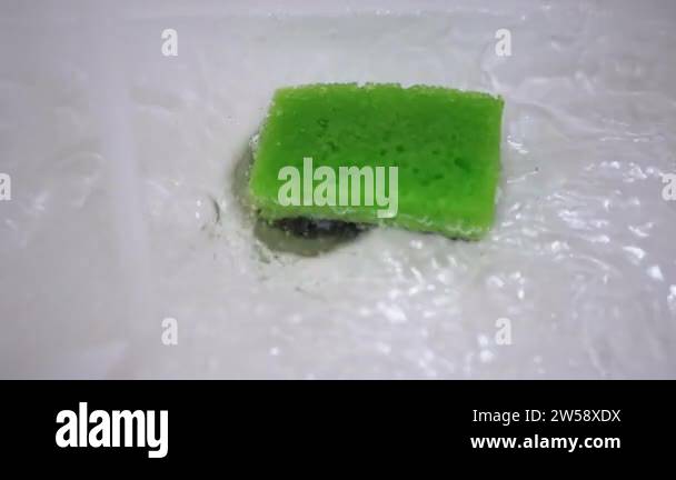 Drain Hole in Sink is Clogged Green Sponge. Bubbling Water Pours Into ...