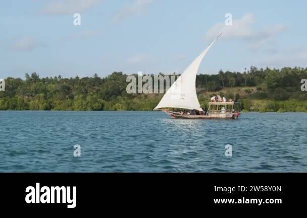 Traditional African Boat Dhow with Tourists Floats under the Open Sail ...