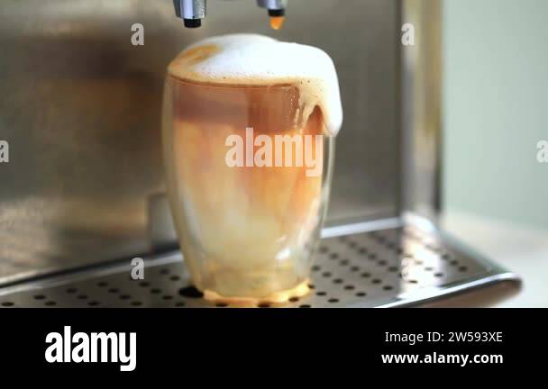 Coffee streaming from coffee machine and pouring out of cup. Home ...