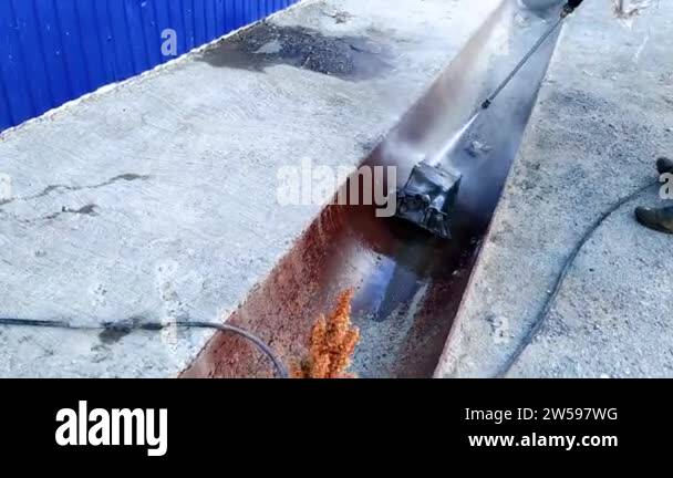 Washing of dirty engine parts outdoor. Unrecognisable mechanic using ...