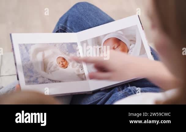 top view. mother and daughter watch photobook from discharge of newborn ...