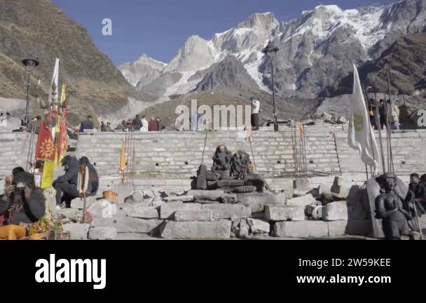 Indian God statue at Kedarnath Temple, snow capped peak in background ...