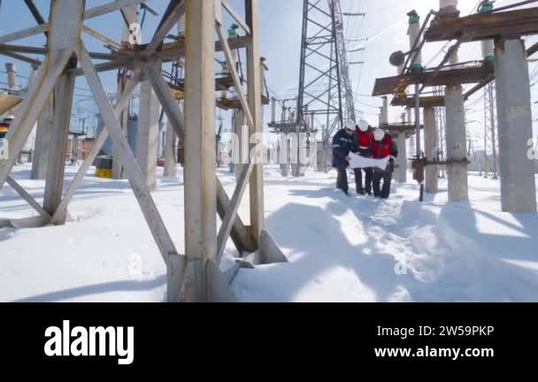 Engineers at electrical substation in winter. Action. Engineers and ...