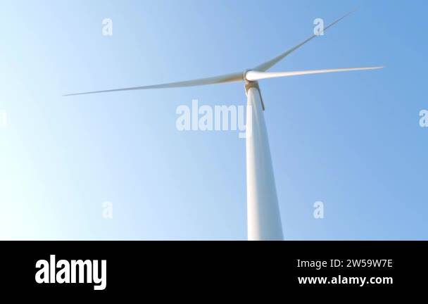 Wind turbine rotating on clear blue sky background. Local eco friendly ...